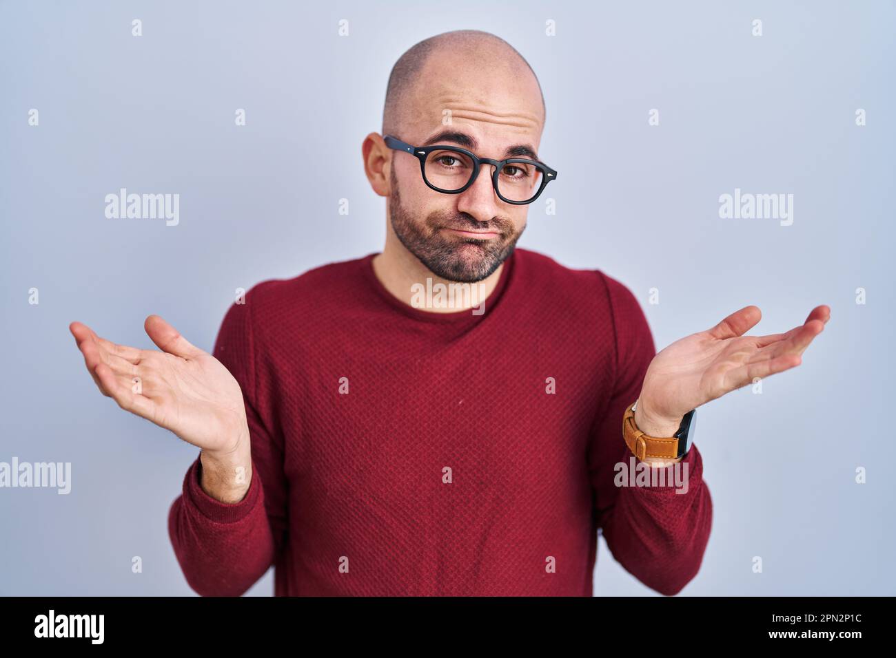 Young bald man with beard standing over white background wearing ...