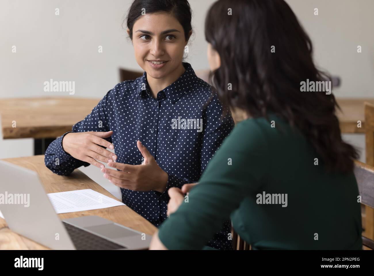 Women colleagues discuss joint task seated at desk with laptop Stock ...