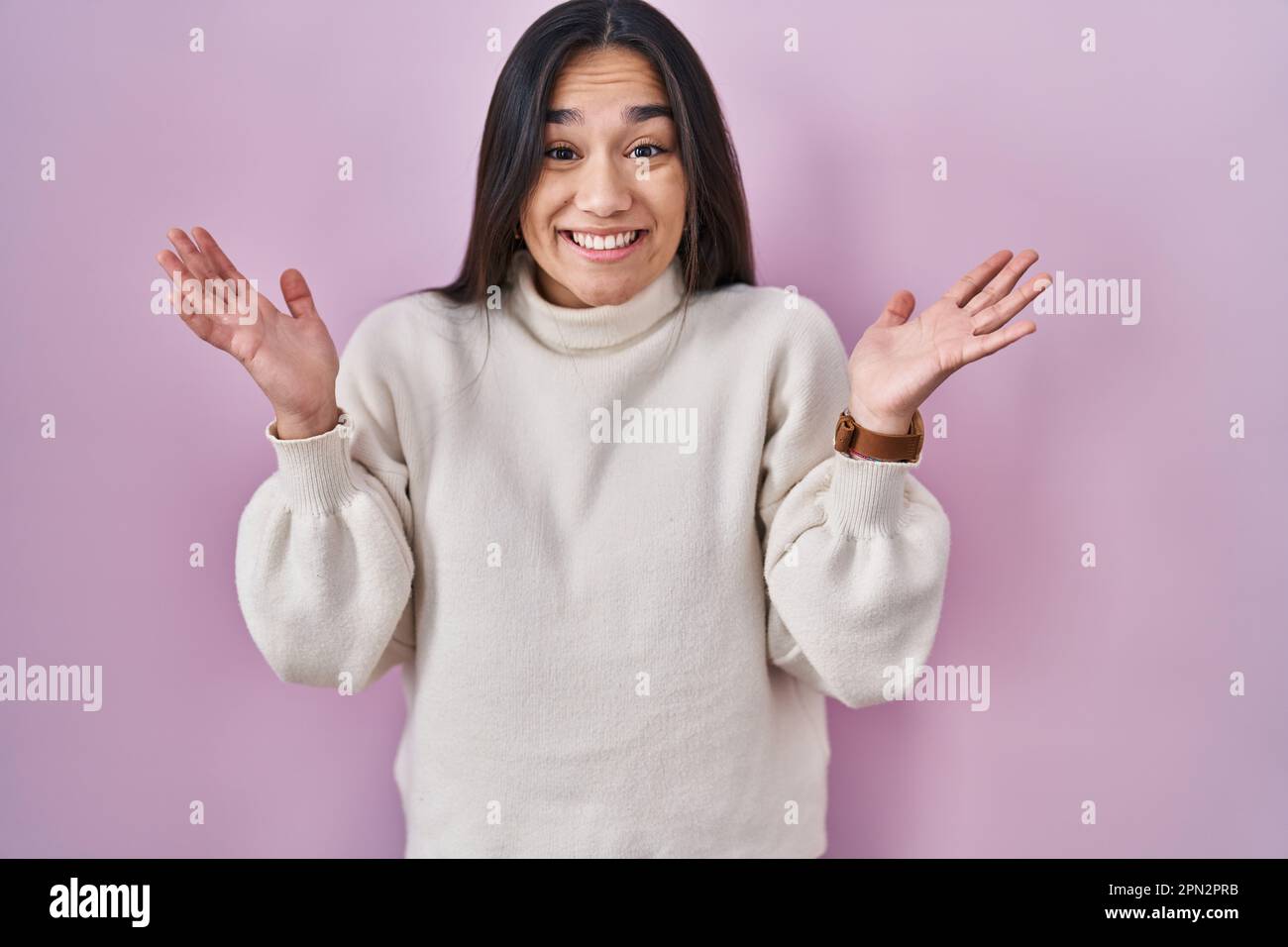 Young south asian woman standing over pink background celebrating crazy ...