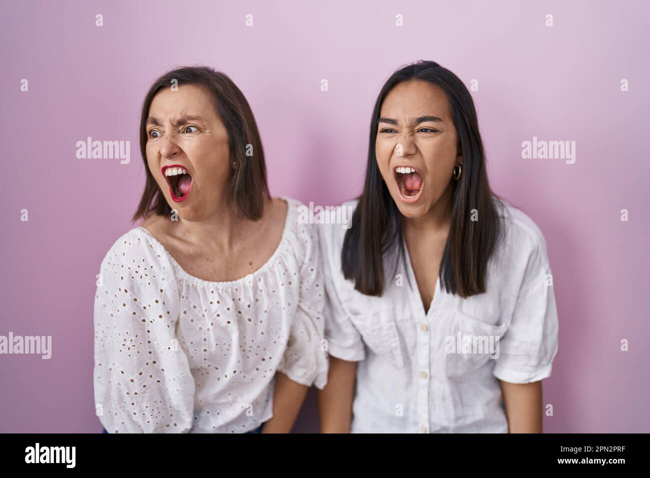 Hispanic mother and daughter together angry and mad screaming ...