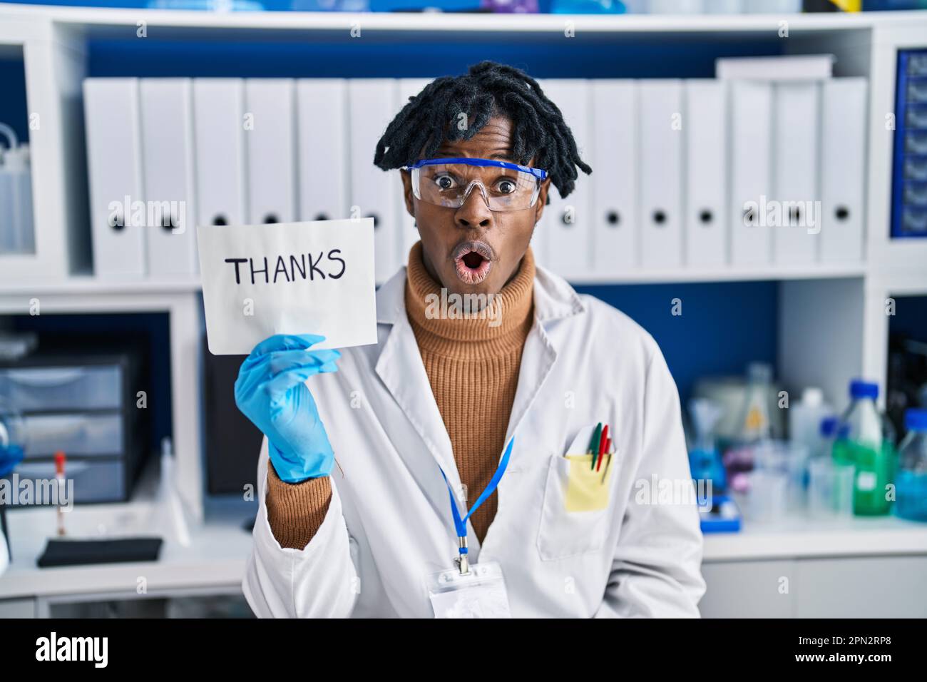 Young african man with dreadlocks working at scientist laboratory ...