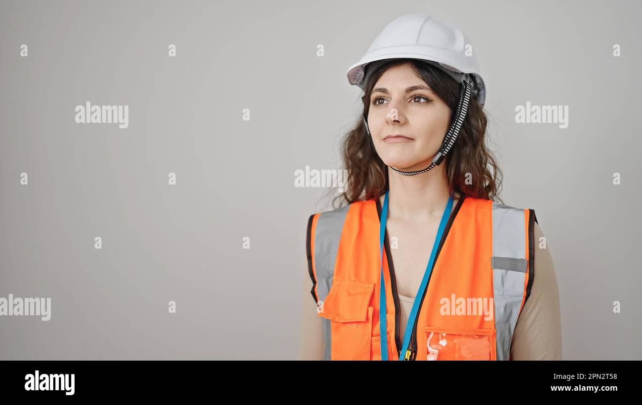 Young beautiful hispanic woman builder standing with relaxed expression ...