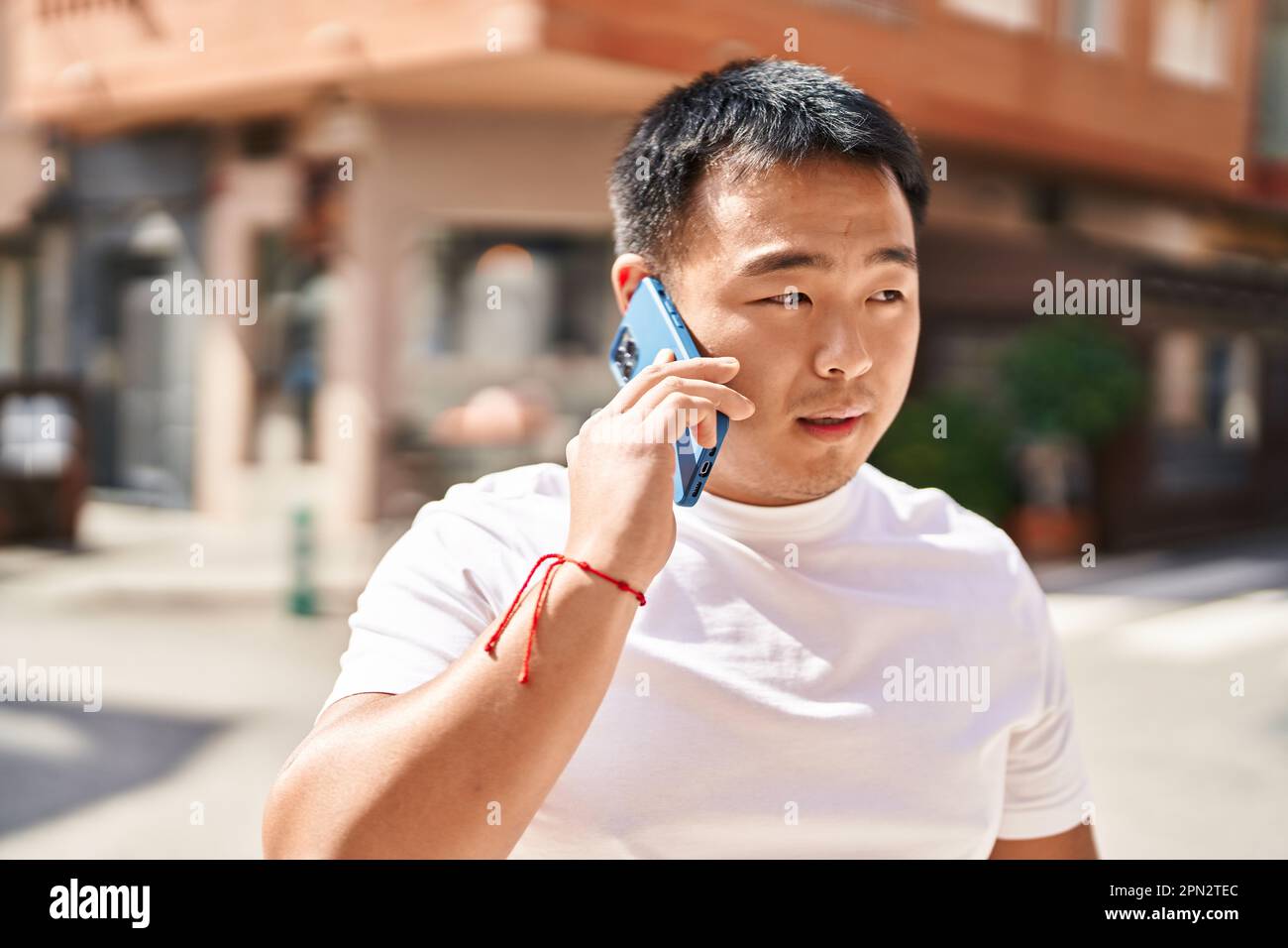 Young chinese man talking on the smartphone at street Stock Photo - Alamy