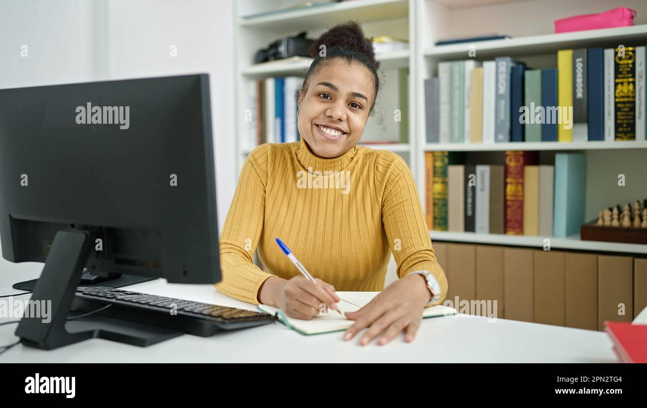 Young african american woman student taking notes at the library Stock ...