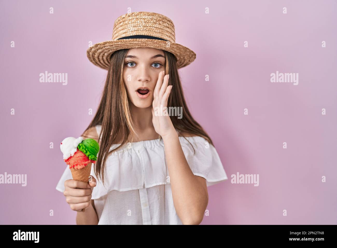 Teenager girl holding ice cream afraid and shocked, surprise and amazed ...
