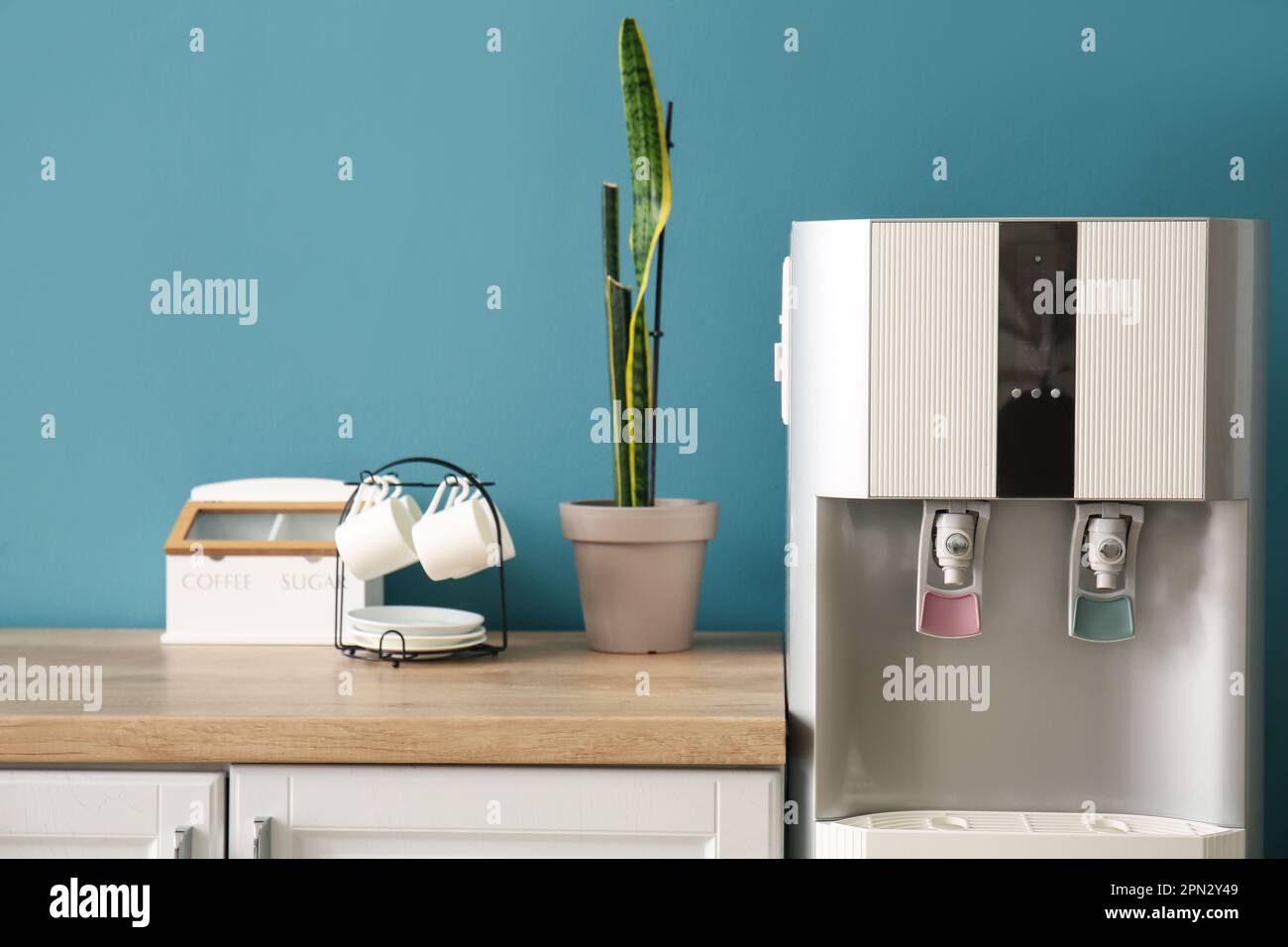 Interior of kitchen with modern water cooler near blue wall Stock Photo ...