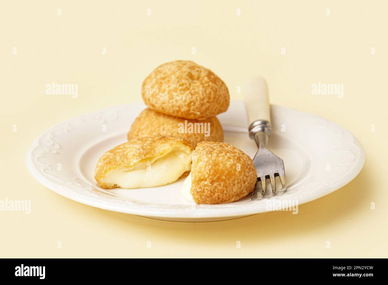 Plate with delicious choux pastry on beige background Stock Photo - Alamy