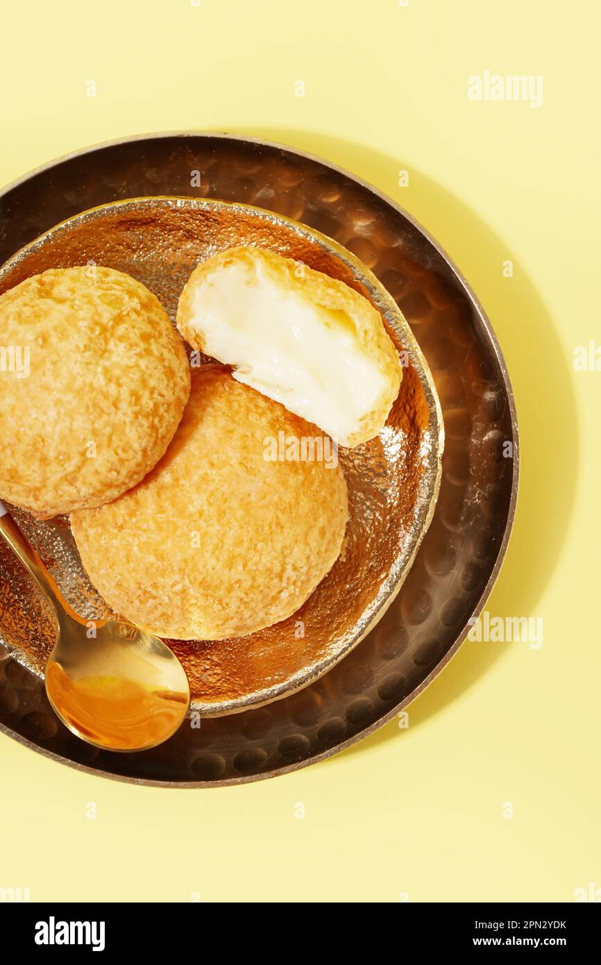 Plate with delicious choux pastry on yellow background Stock Photo - Alamy