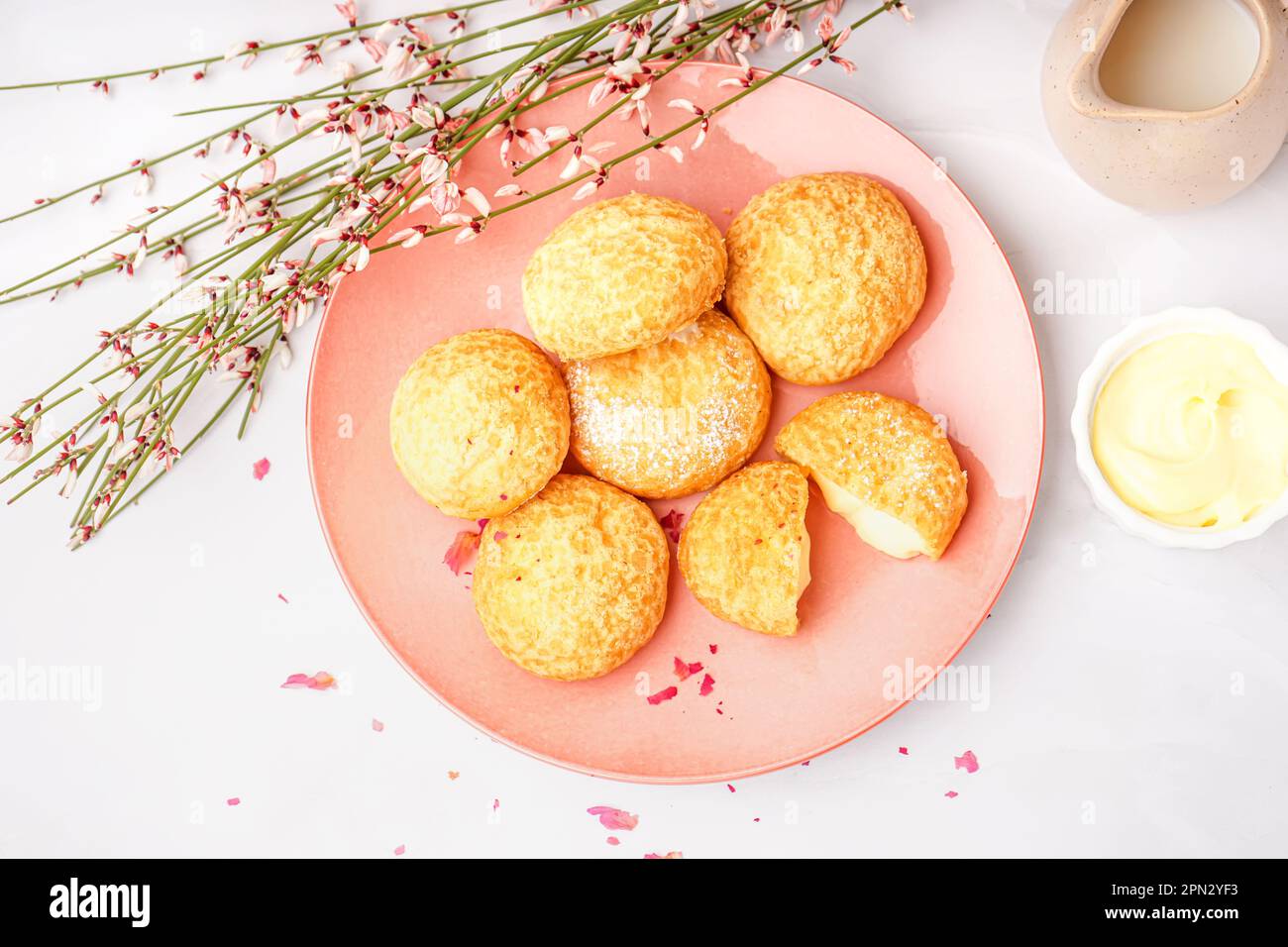Plate with tasty choux dessert on white background Stock Photo - Alamy