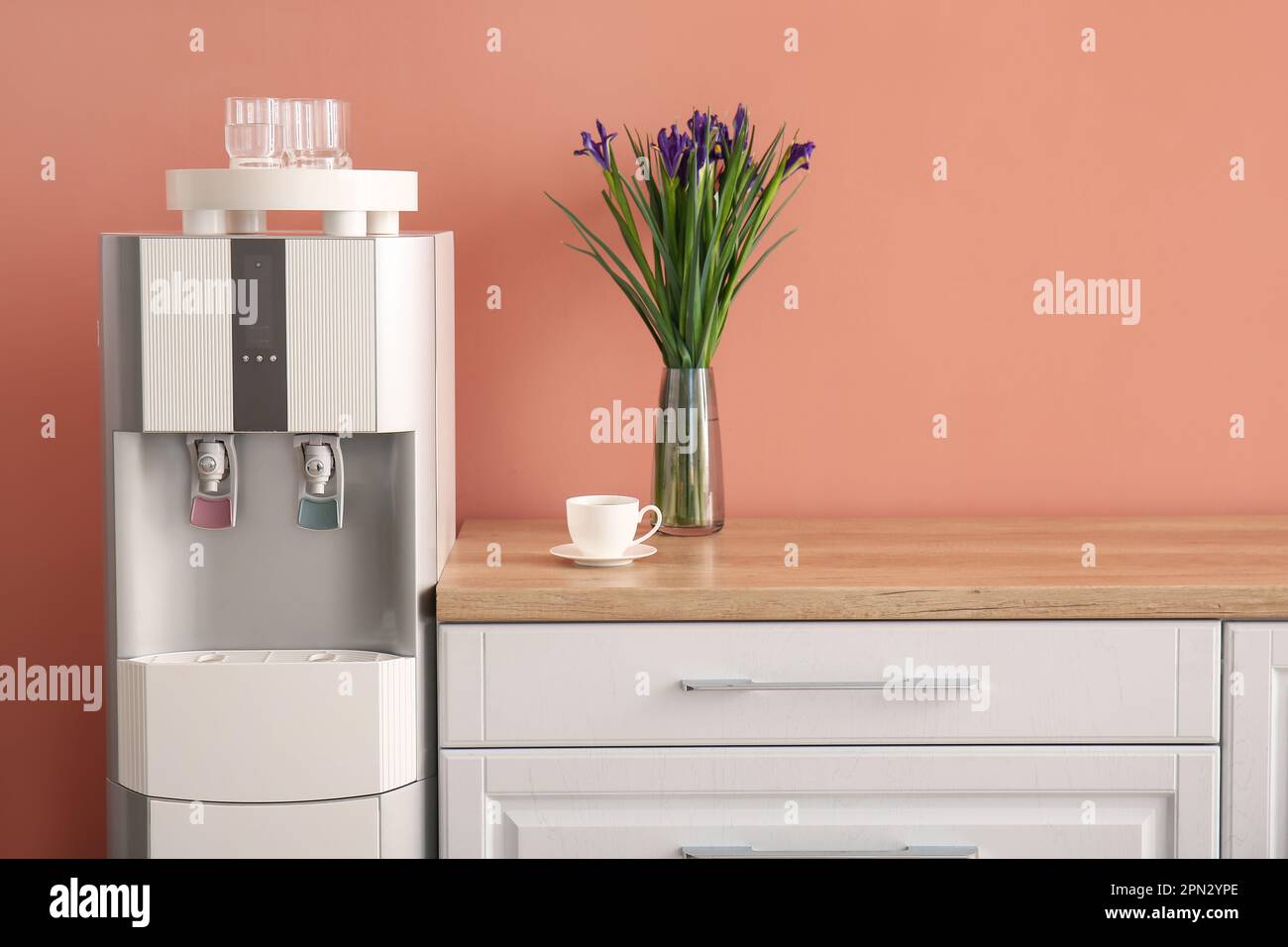 Interior of kitchen with modern water cooler near coral wall Stock ...