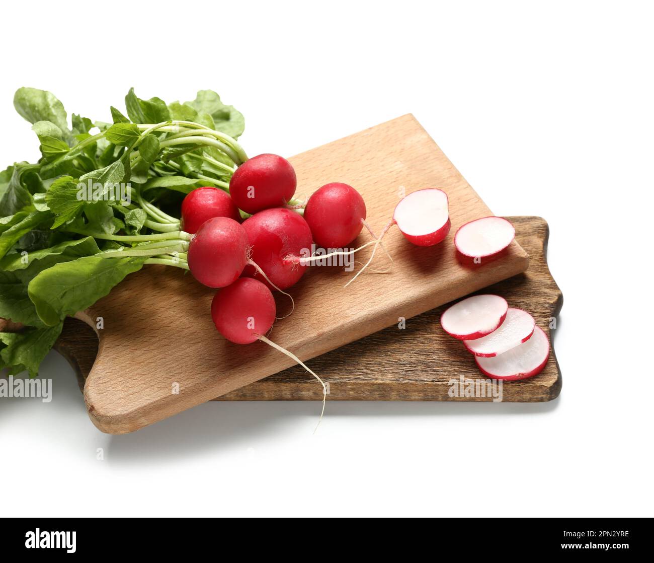 Wooden boards of ripe radish with green leaves on white background ...