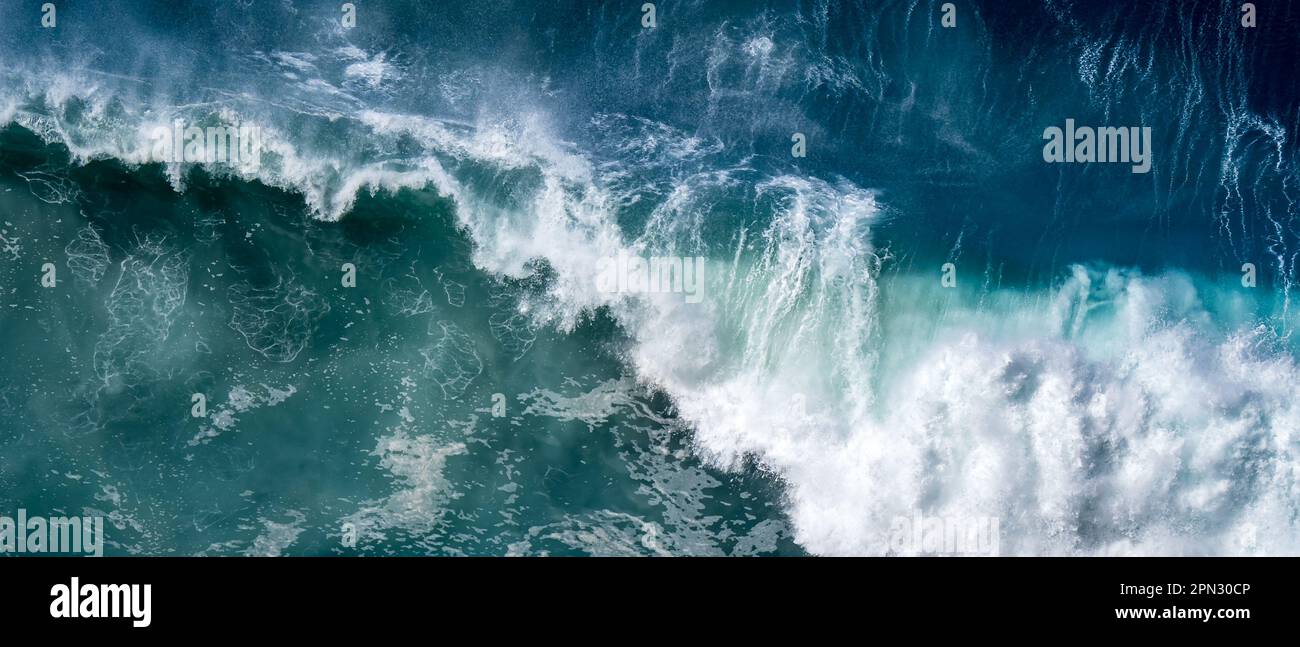 A roaring wave crashes into the deep waters, creating a mesmerizing ...