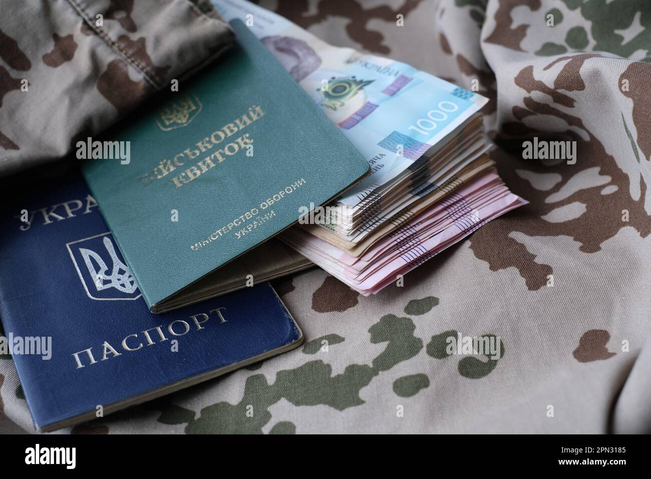 Ukrainian military ID and hryvnia on military uniform. Payments to ...