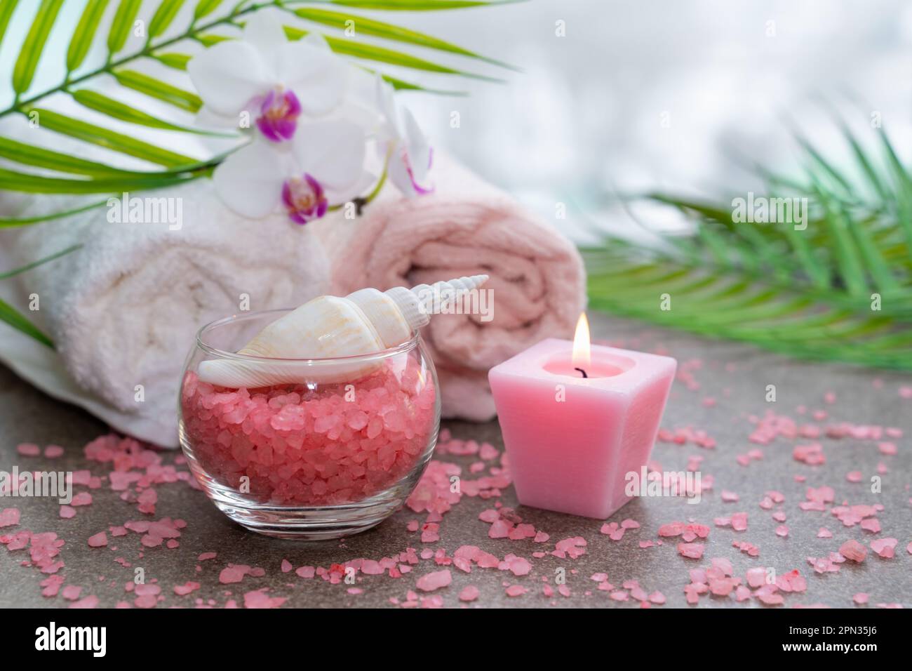 Starfish, seashells, terry towel, candle and plant on the sand. Spa and ...