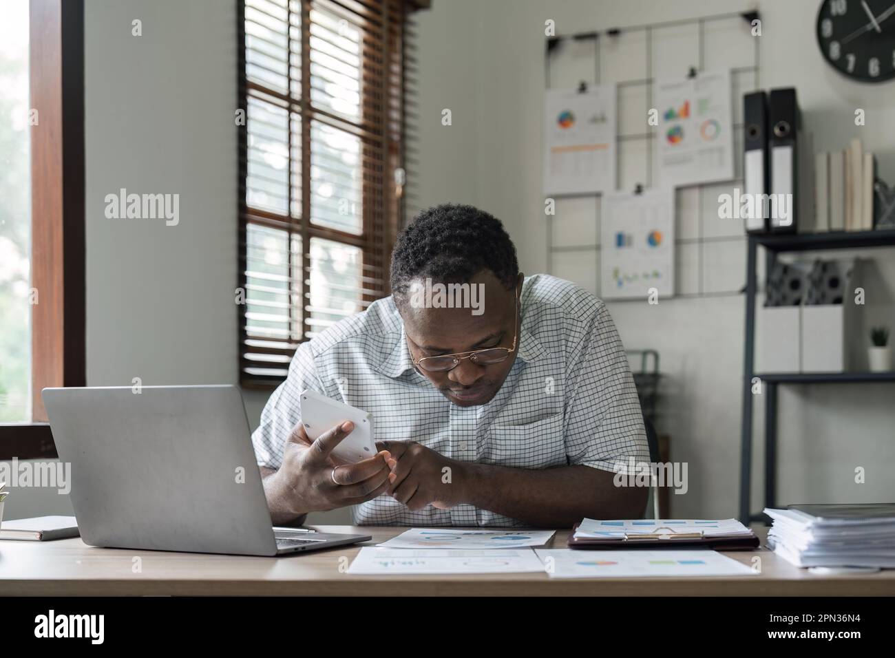 African American man calculating using machine managing household ...