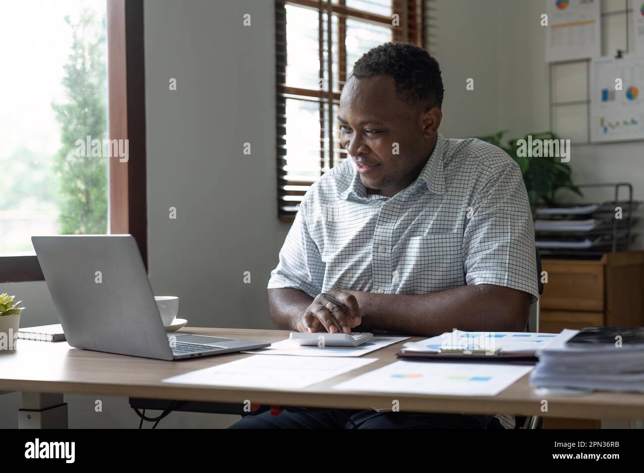 African American man calculating using machine managing household ...