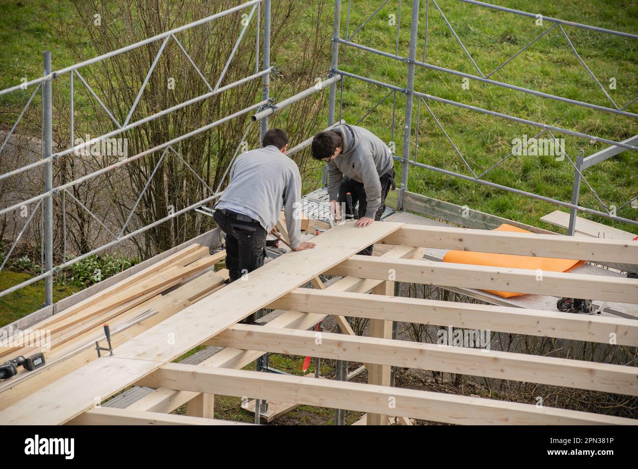 Two young carpenters building a carport. Apprentice learns from trainer ...