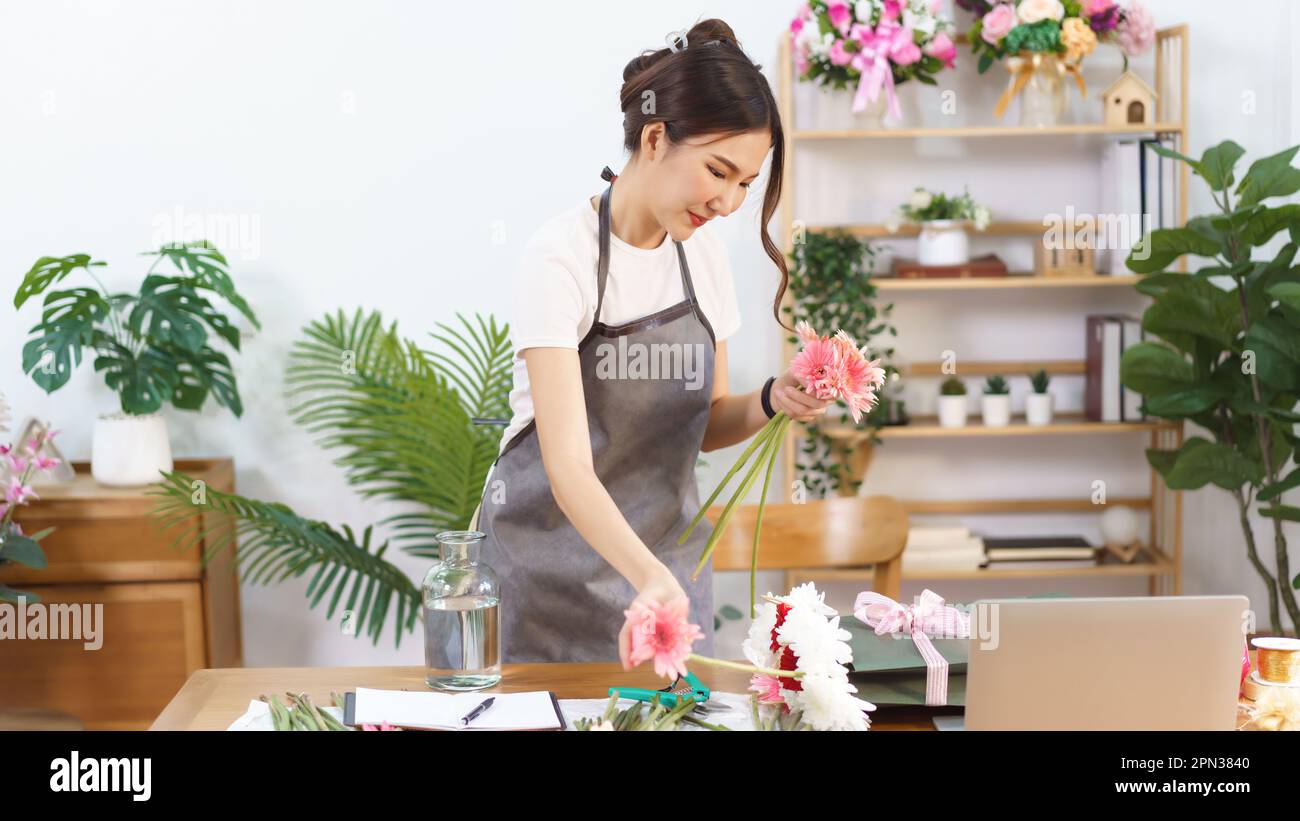 Flower shop concept, Female florist grab colorful gerbera in shopping ...