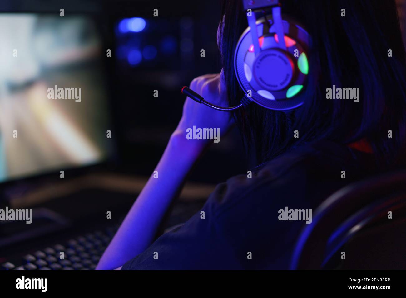 Female cyber hacker gamer in headphone serious face to playing games or ...