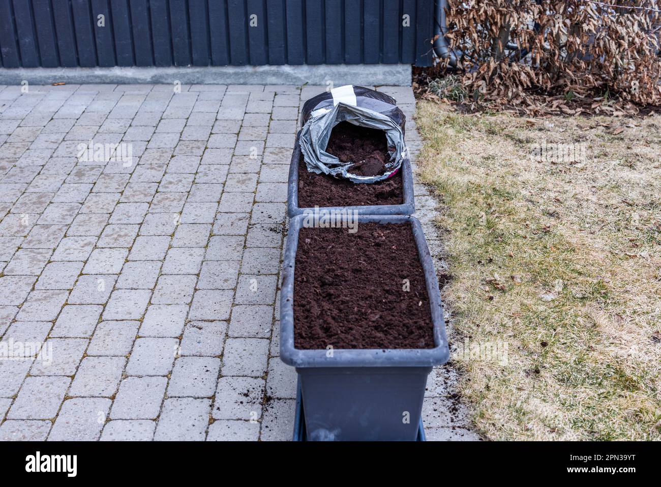 View of bag of earth and boxes of soil prepared for planting flowers ...