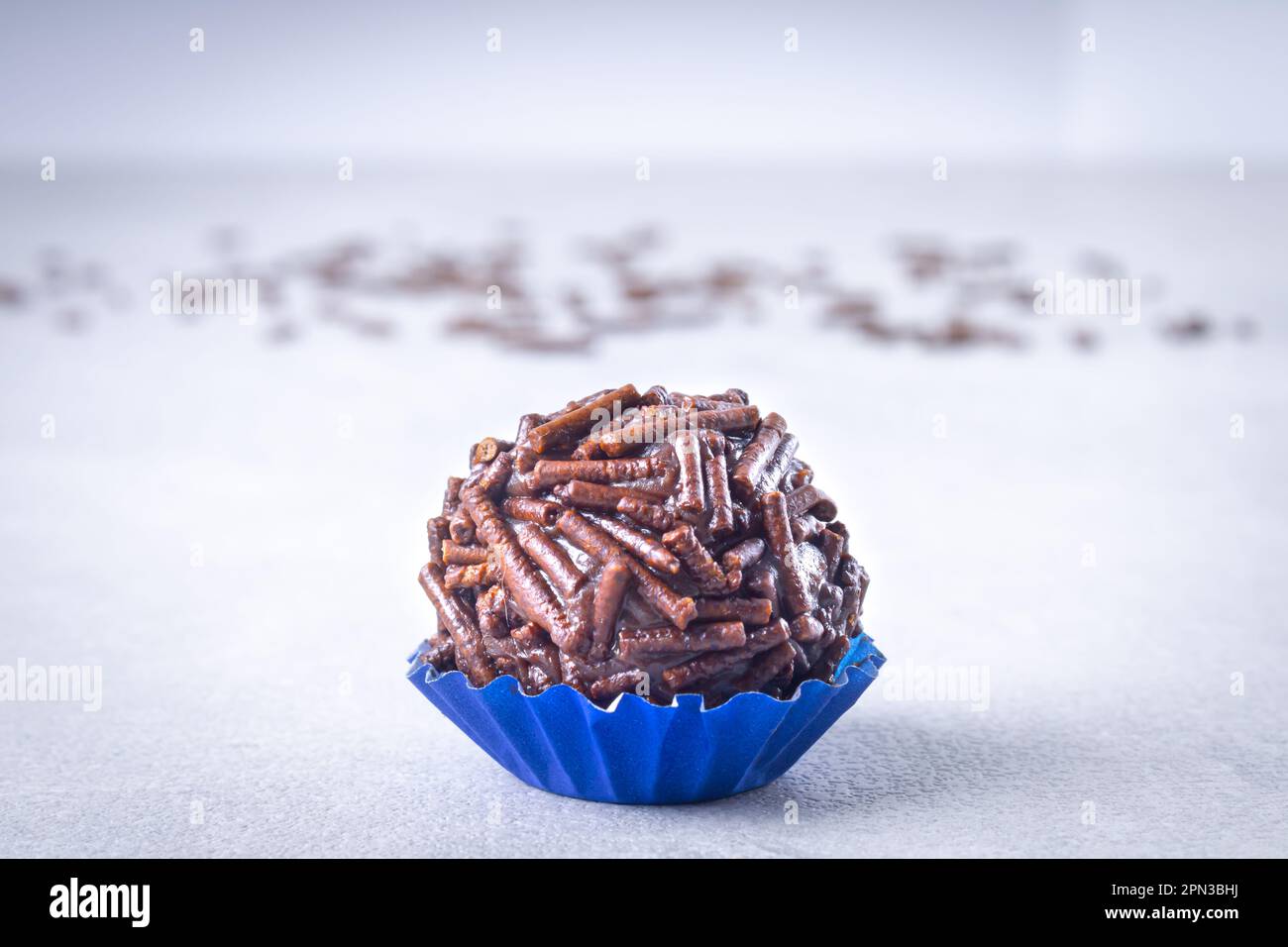 Brigadeiro candy in a blue shape on a white background with chocolate ...