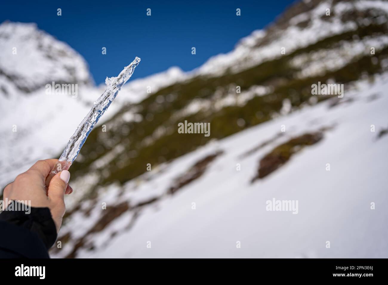 Hand with the magic wand of ice, icicle, mountains, blue sky Stock ...