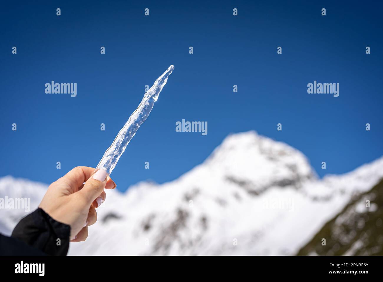 Hand with the magic wand of ice, icicle, mountains, blue sky Stock ...