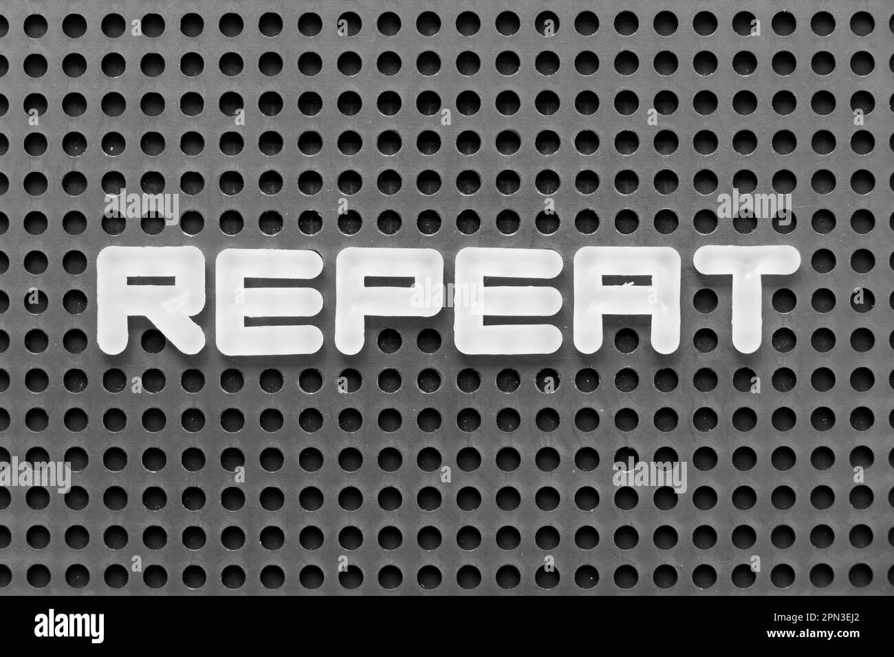 White alphabet letter in word repeat on black pegboard background Stock ...