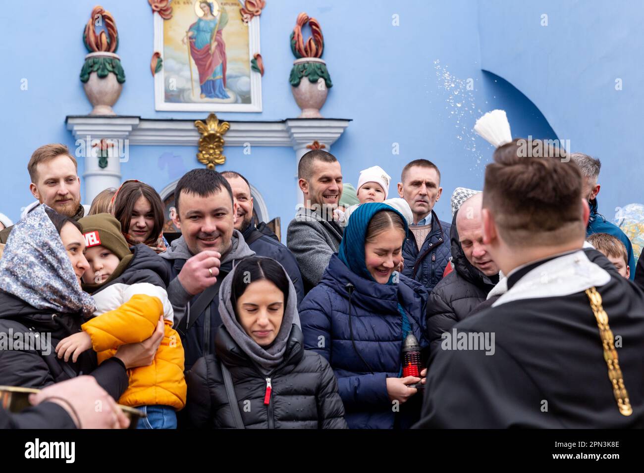 A priest blesses Ukrainian believers with Holy Water as they attend the ...