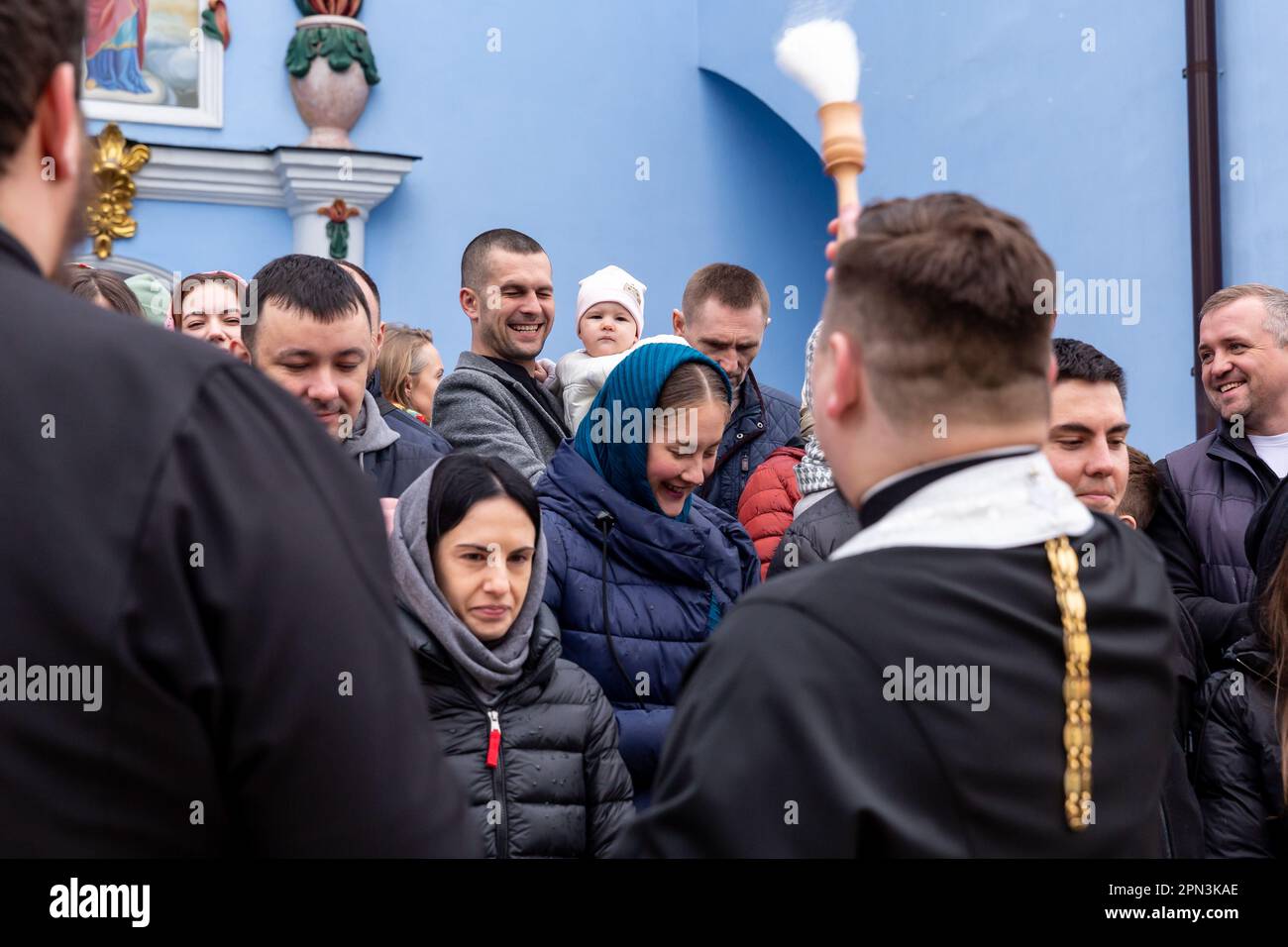 A priest blesses Ukrainian believers with Holy Water as they attend the ...