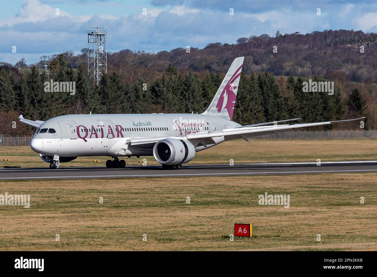 A large Qatar Airway plane taking flight from an airport flight strip ...
