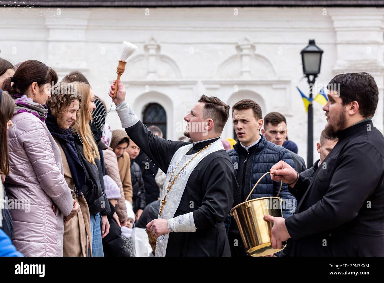 A priest blesses Ukrainian believers with Holy Water as they attend the ...