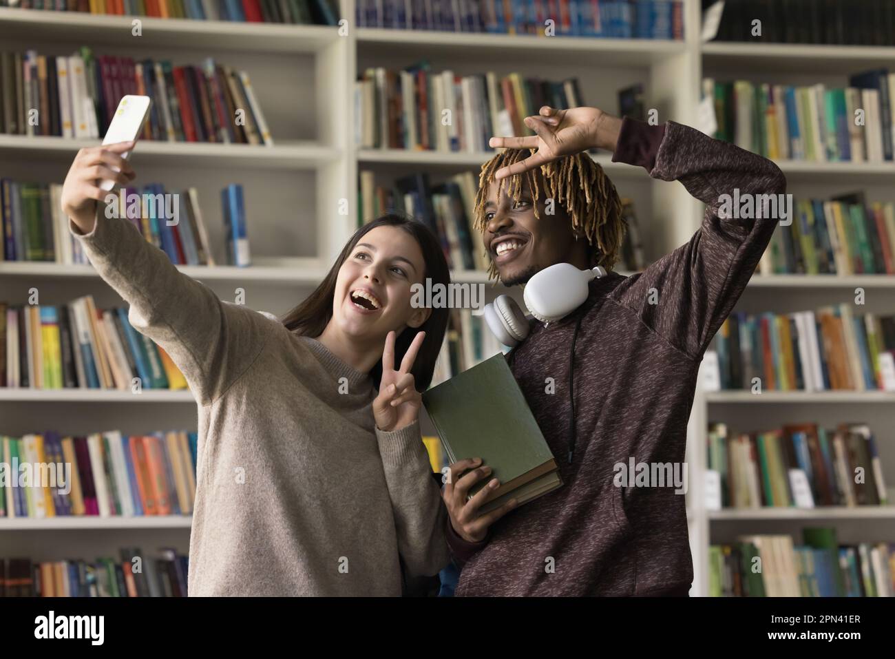 Two happy students make selfie in library Stock Photo - Alamy