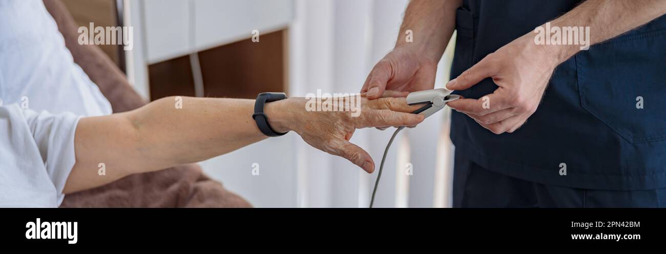 Nurse checking with fingertip pulse oximeter oxygen saturation of ...