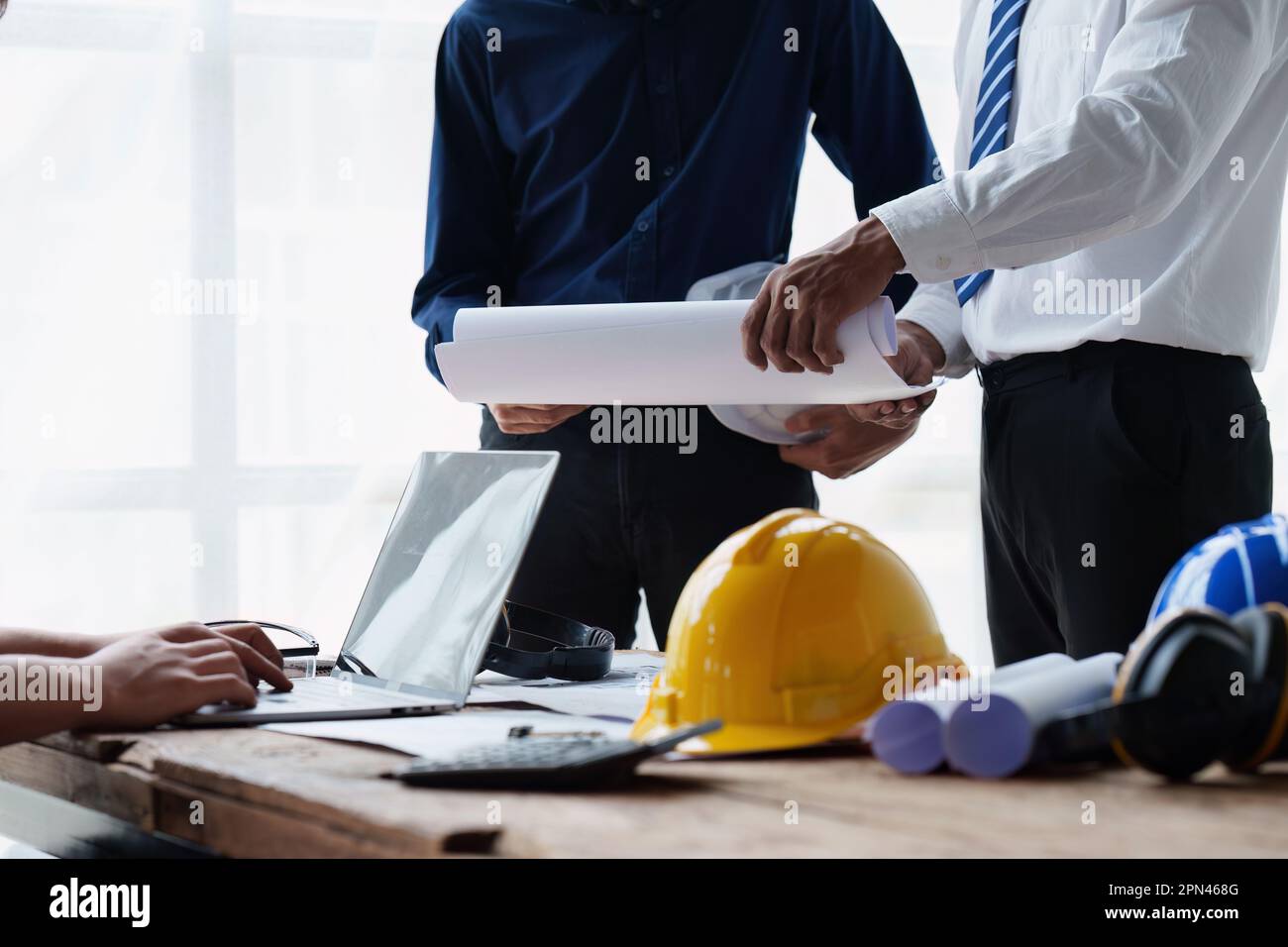 Architect and Engineer working with blueprints for architectural plan ...