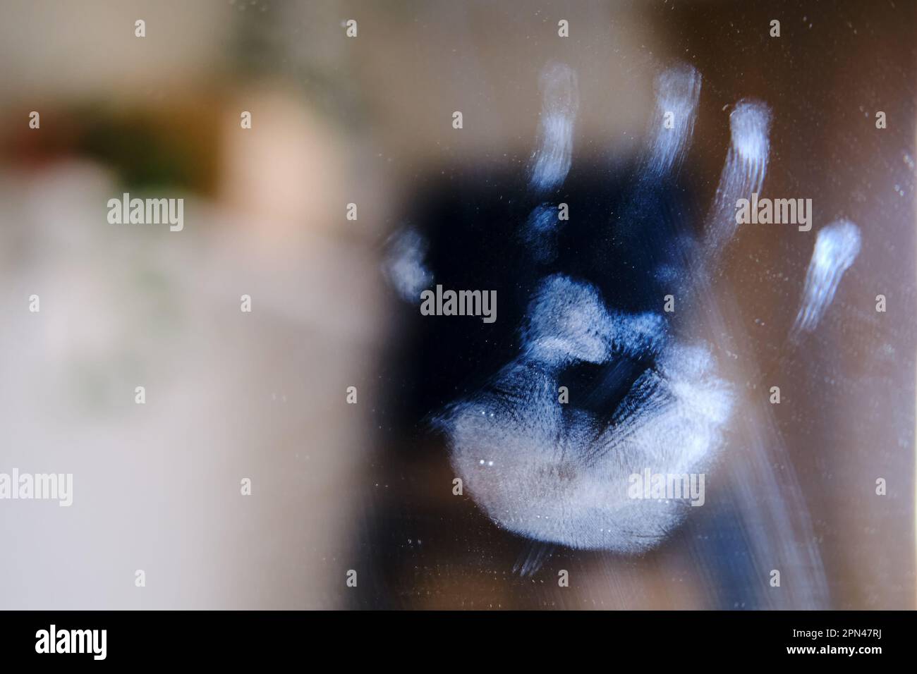 A child's palm print and dirt on the window glass from hands. Traces of ...