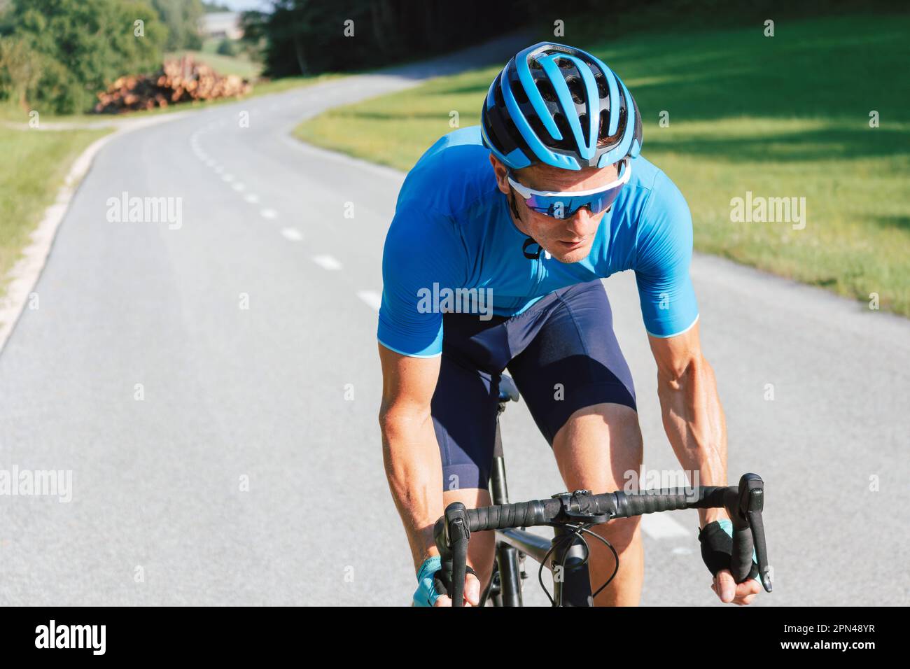 Professional road cycling male racer taking an aerodynamic body ...
