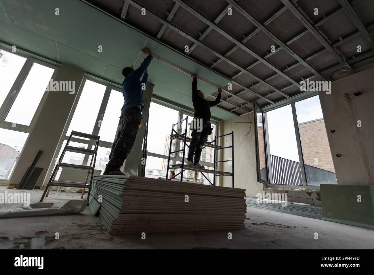 Drywall Installers. Men holding a gypsum board figured cut Stock Photo ...