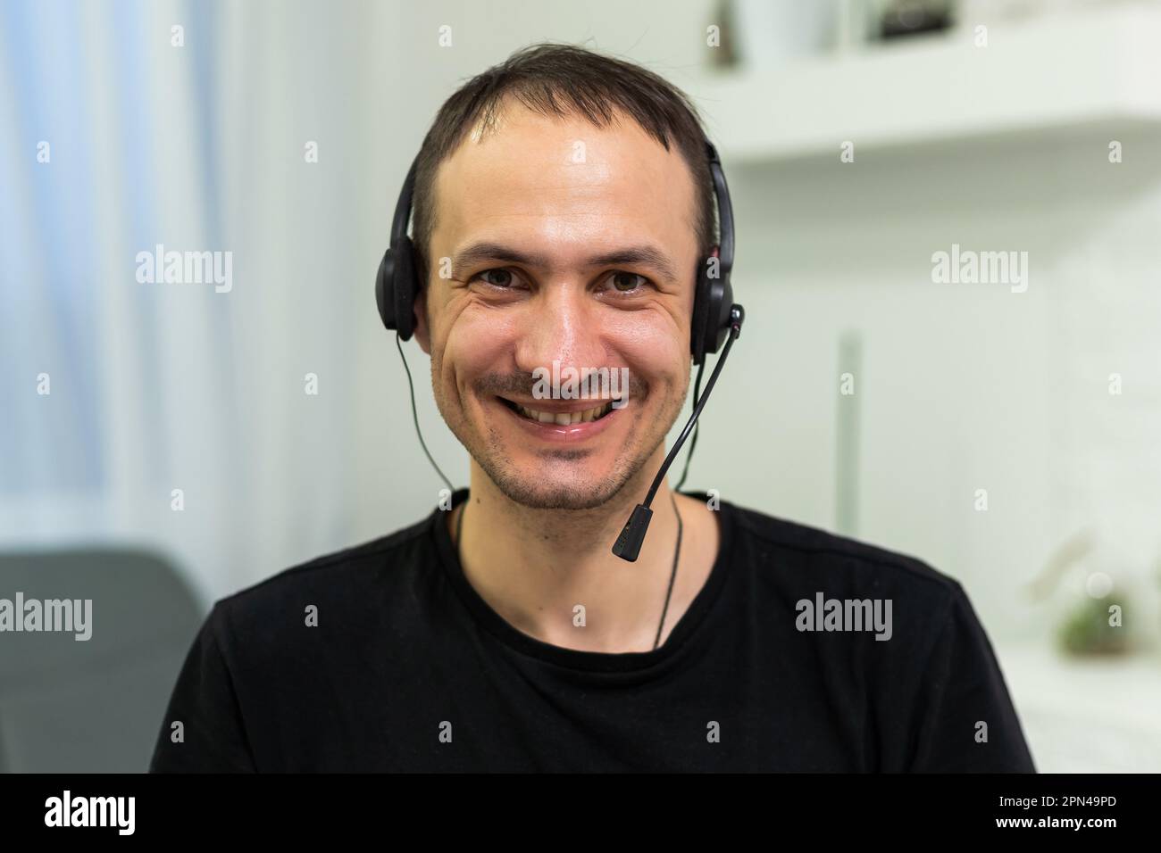 Smiling young man working on laptop in modern kitchen, checking email ... Smiling young man working on laptop in modern kitchen, checking email ...