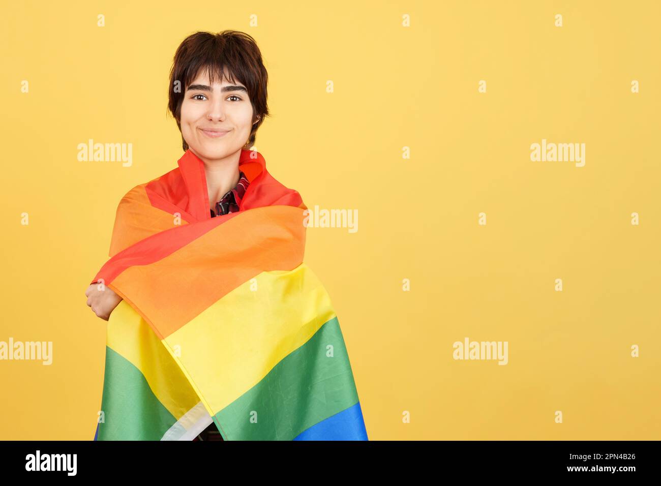 Androgynous person wrapped with a lgbt flag Stock Photo - Alamy