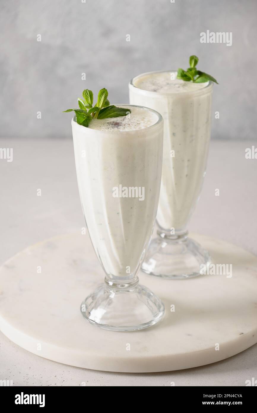Indian Salty lassi with mint leaves and kala namak on white background ...