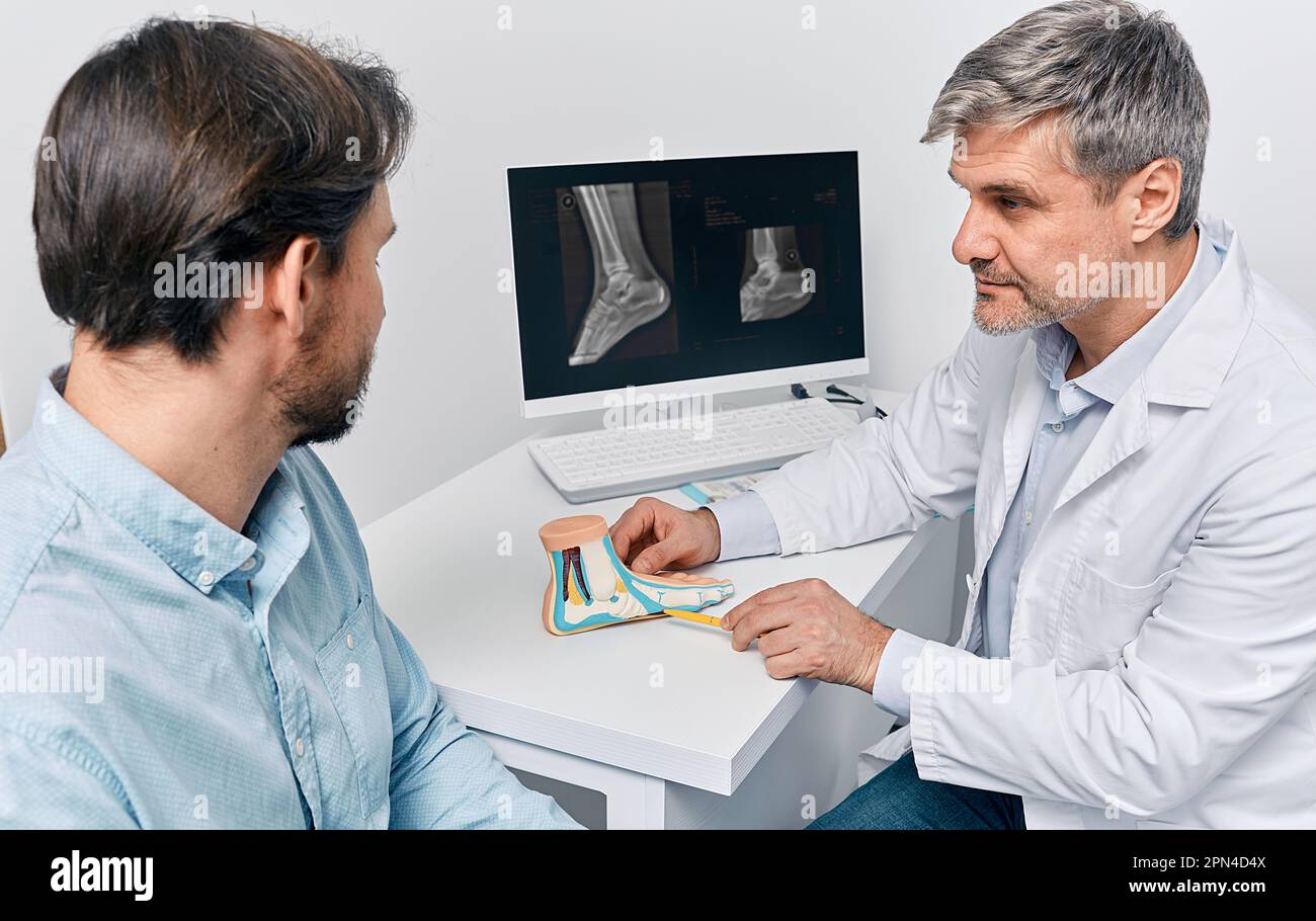 Orthopedic doctor consulting adult man with pes planus, explaining ...