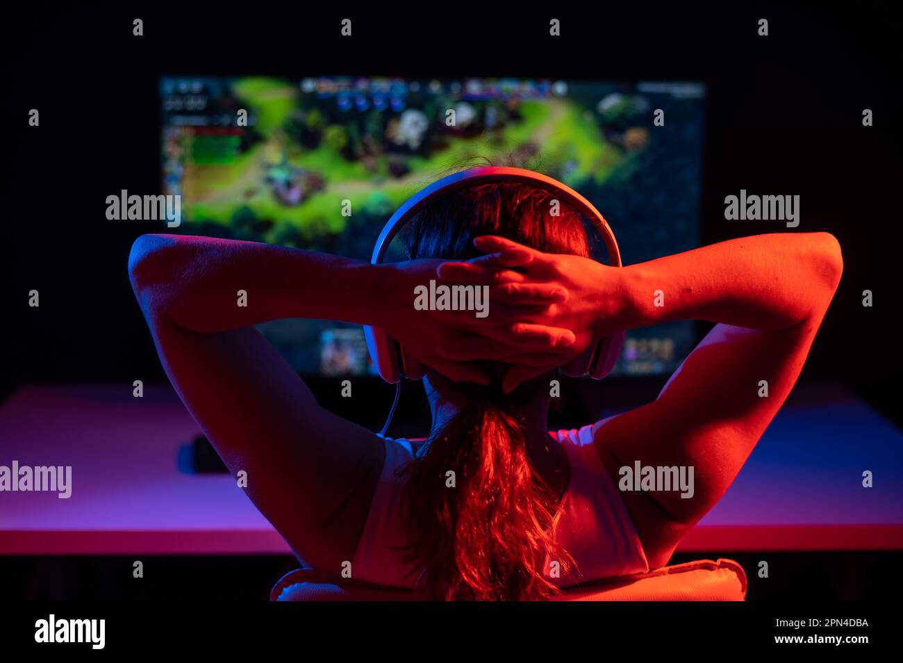 Caucasian woman upset after losing a computer game in neon light in the ...