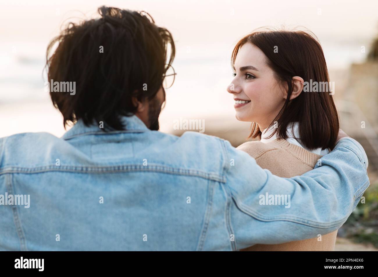 Smiling millennial indian guy hugging caucasian woman, enjoy romantic ...
