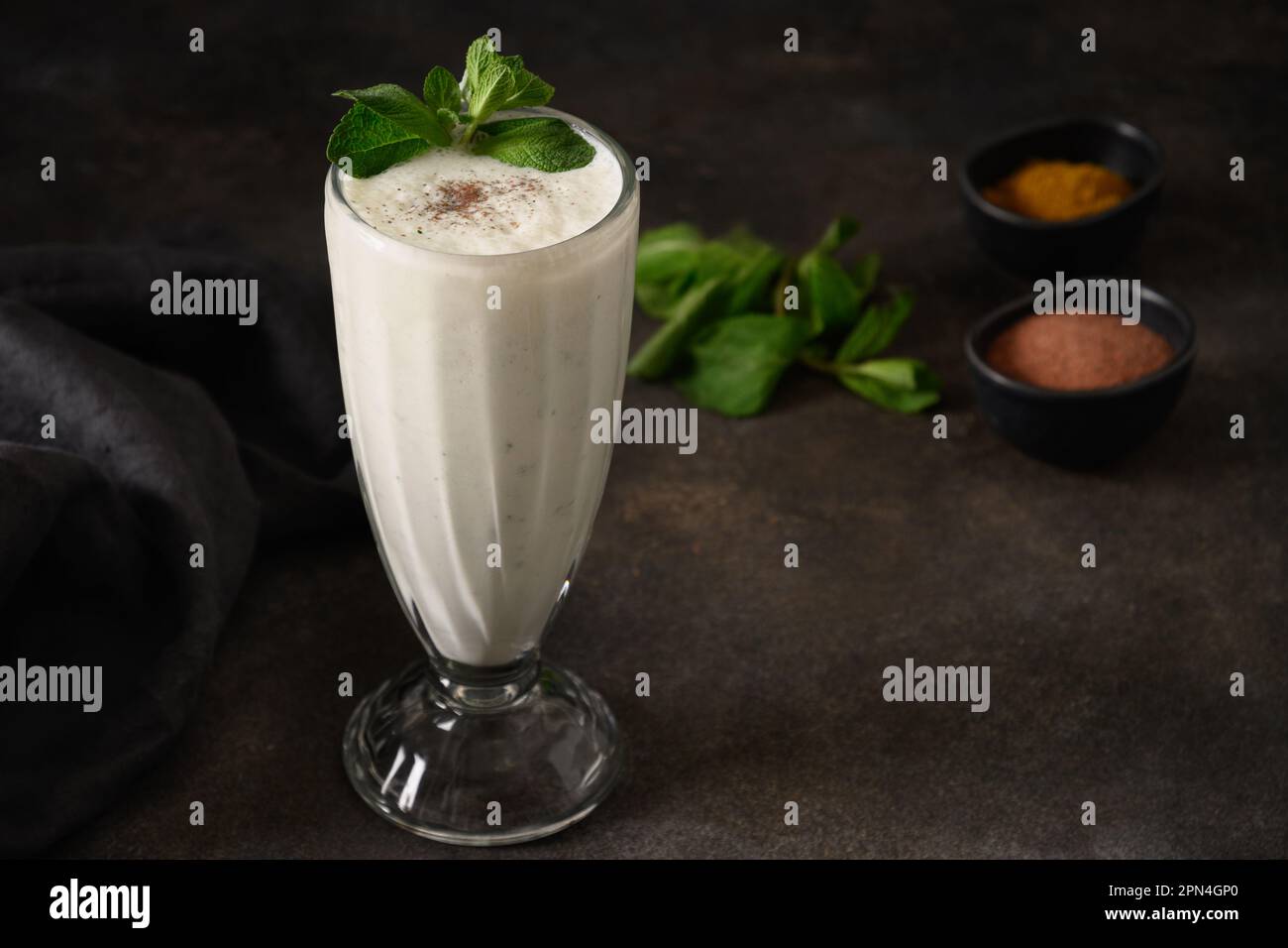 Indian Salty lassi with mint leaves and kala namak on black background ...