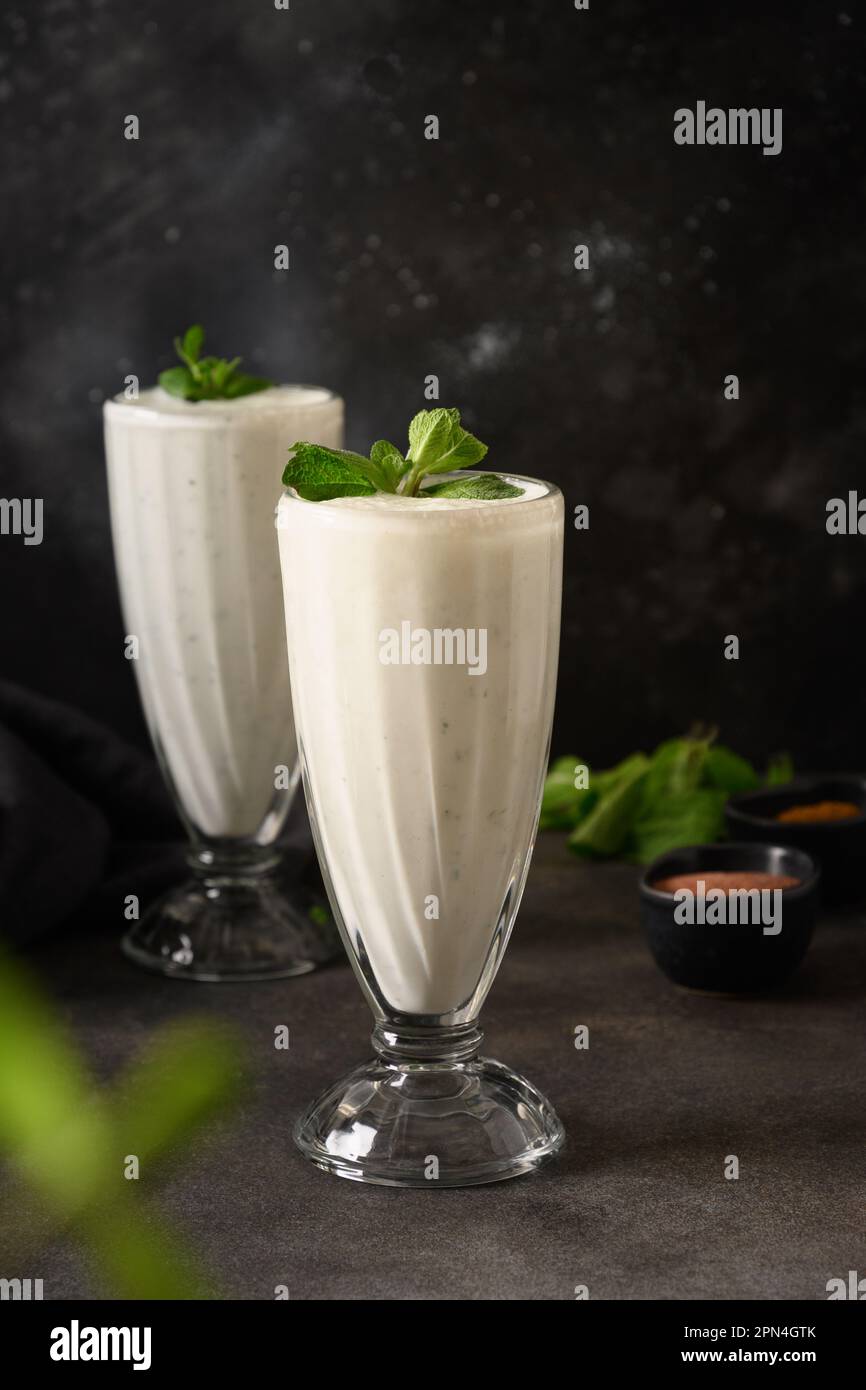 Indian Salty lassi with mint leaves and kala namak on black background ...