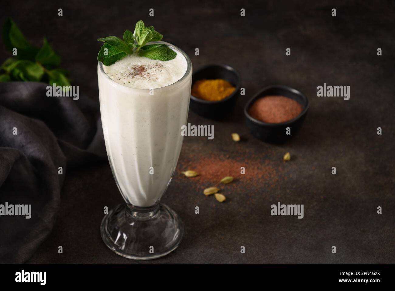 Indian Salty lassi with mint leaves and kala namak on black background ...