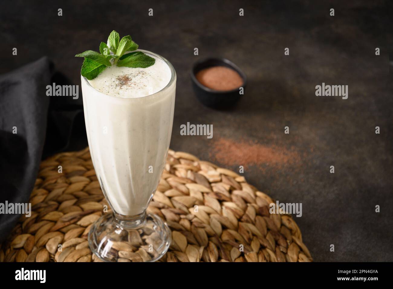 Indian Salty lassi with mint leaves and kala namak on black background ...