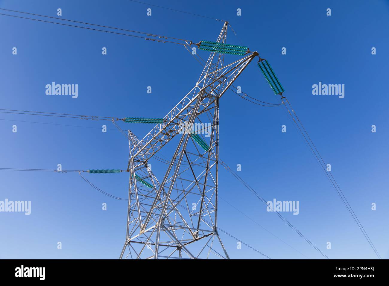 Close up on the top section of a high voltage transmission pylon with ...