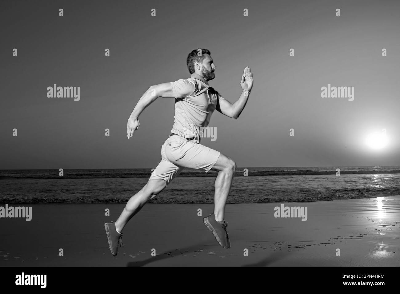 Man running on the beach at sunset. Guy runner jogger running. Dynamic ...